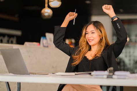 문서와 노트북으로 사무실에서 결과를 보여주는 차트와 그래프를 작업하는 아시아 사업가 재무 지표를 계산하는 작업자 문서 미소 짓고