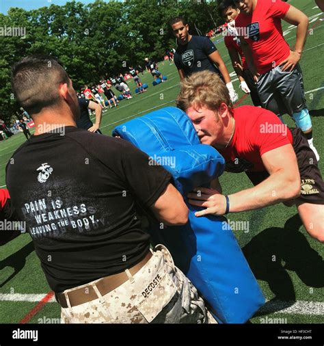 Sergeant Paul Decoste Holds A Body Pad As High School Football Players Rehearse Offensive Drills