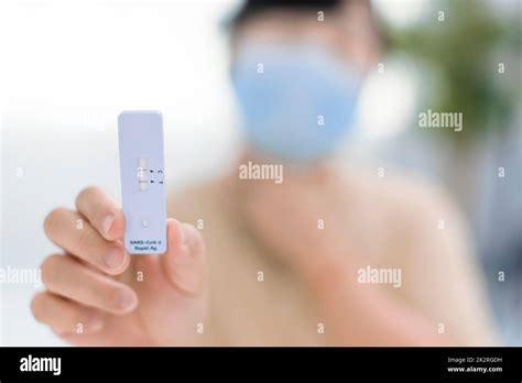 Woman Holding Rapid Antigen Test Kit With Positive Result During Swab COVID 19 Testing Stock