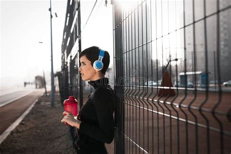 Woman Listening To Music While Working Out And Jogging Outdoor Stock