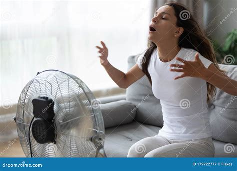 Overheated Woman Enjoying Fresh Air Cooling Herself By Electric Fan