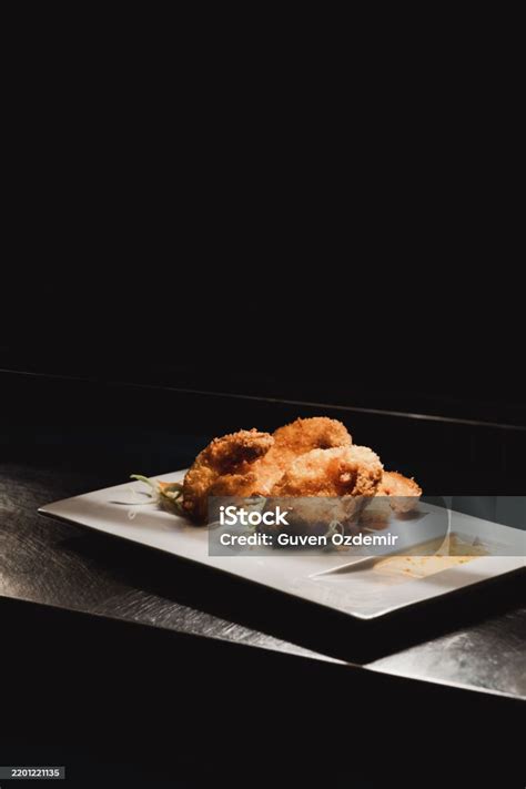 하얀 직사각형 접시에 디핑 소스를 곁들인 황금빛 바삭한 태국 스타일의 빵가루 입힌 새우 드라마틱한 조명에서 맛있는 해산물 애피타이저 제공 0명에 대한 스톡 사진 및 기타