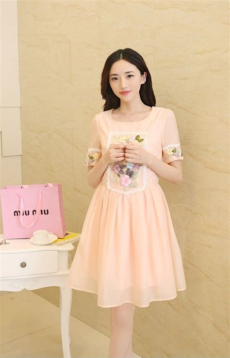 ชุดเดรส ผ้าชีฟอง ชนิดเนื้อทราย สีชมพูโอรส หน้าอกและปลายแขนเสื้อ แต่งด้วยผ้าริบบิ้น รูปดอกไม้ สวย