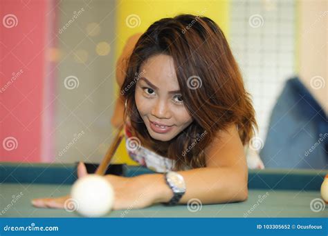 演奏落袋撞球的年轻俏丽和愉快的亚裔女孩拿着棍子在夜总会或酒吧的撞球台上 库存照片 图片 包括有 使用 女孩 103305652