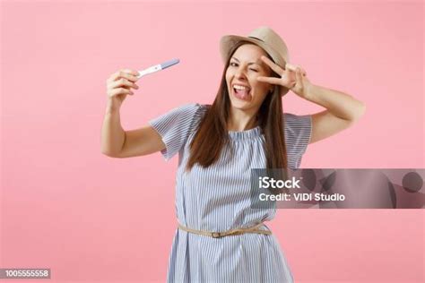 파란 드레스에 흥분된 행복 한 여자 모자 잡고 손 임신 테스트 분홍색 바탕에 고립 된 보고 의료 의료 부인과 임신 임신 출산 사람들 개념 공간에 복사 합니다 건강 진단에