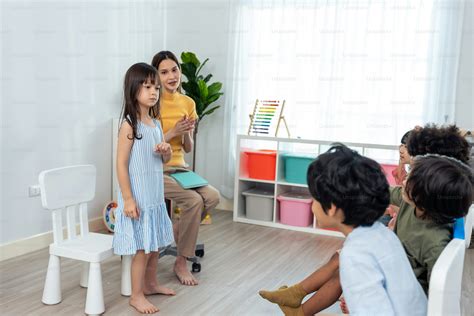 아시아의 아름다운 젊은 여성 교사가 학교에서 아이에게 수업을 가르치고 있다 매력적인 여성 강사 마스터가 유치원 교실에서 재미있는 활동으로 어린이 학생을 설명하고 교육합니다