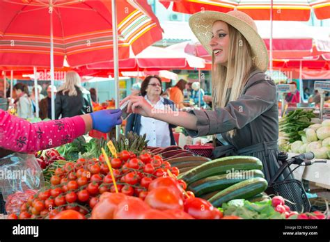 Attractive Blonde Girl With Straw Hat Posing On Flower Marketplace