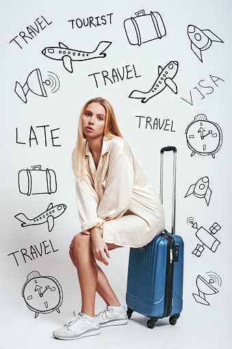 기다리고 예쁜 금발 여자의 전체 길이는 비행을 기다리고 다른 여행 낙서와 회색 배경에 그녀의 짐에 앉아 여행 컨셉 여행 개념에 대한 스톡 사진 및 기타 이미지 Istock