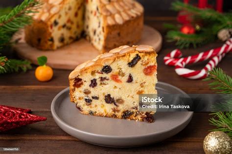나무 판에 말린 과일과 아몬드를 곁들인 전통적인 크리스마스 던디 케이크 축제 디저트 소박한 스타일 선택적 초점 독일 문화에 대한