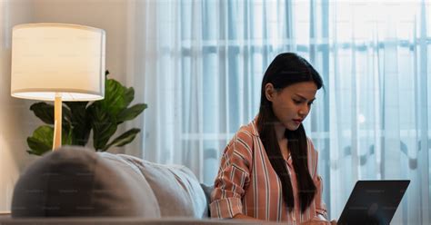 좌절한 아시아 사업가 여성은 밤늦게까지 사무실에서 과로합니다 매력적인 아름다운 여성 직원 또는 학생이 소파에 앉아 노트북 컴퓨터에서 작업하는 동안 스트레스와 실망을 느낀다