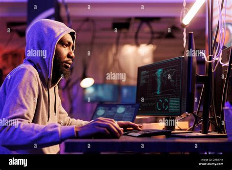 Hacker In Hood Breaching Company Cybersecurity System On Computer Young African American Man