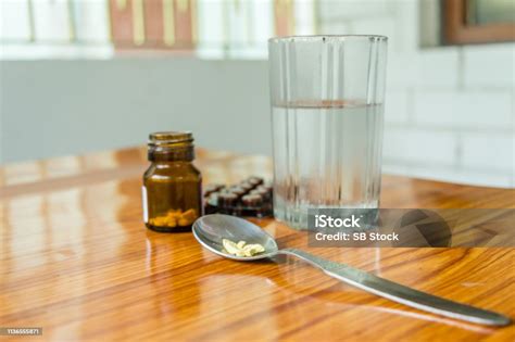 항 산화 제 비타민 정제 알 약 물집 약물의 병 계량 스푼의 캡슐을 테이블에 놓은 물과 함께 볼 수 있습니다 의료 약국 테마 측면 보기 복사 공간을 닫습니다 0명에 대한