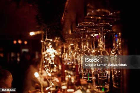 와인 잔 레스토랑의 바 위에 매달려 있는 안경 와인에 대 한 빈 안경입니다 레스토랑의 바 랙 위의 선반에 와인과 마티니 안경 푸른 빛 푸른 배경 밤 생활 0명에 대한 스톡