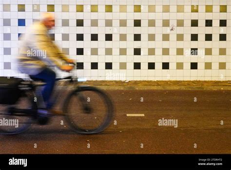 A Senior Citizen Cyclist Crosses An Underpass On A Cycle Path Stock