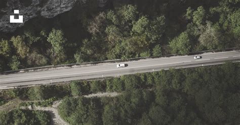 두 대의 자동차가 있는 숲 한가운데에 있는 회색 콘크리트의 항공 사진 사진 Unsplash의 무료 자동차 이미지