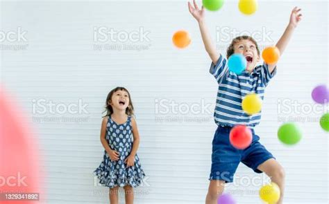 백인 작은 사랑스러운 형제 소년과 소녀는 웃고 비명을 지르고 생일 파티를 축하하고 행복과 장난과 함께 다채로운 공을 연주합니다 교육 가족 개념 다중 색상에 대한 스톡 사진