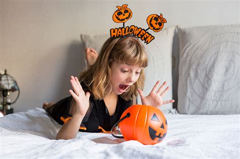 침대에 웃고 할로윈 의상을 입고 아름다운 어린 소녀 호박을 가지고 노는 집 실내 라이프 스타일 10월에 대한 스톡 사진 및 기타 이미지 Istock