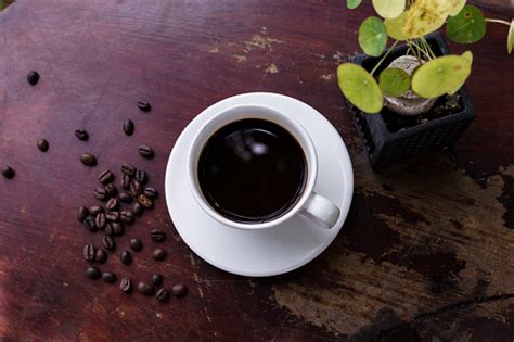 오래된 나무 테이블에 뜨거운 아메리카노 커피 접시에 커피 한 잔 아메리카노 블랙 커피 나무 바닥에 커피 컵 오후는 커피를 마시는 가장 좋은시기입니다 0명에 대한 스톡 사진