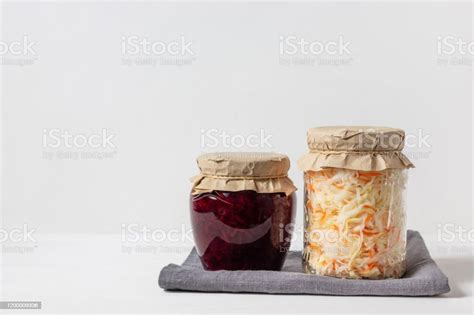당근과 양배추 샐러드를 곁들인 수제 소금에 절인 양배추 샐러드를 유리 병에 담아 흰색 나무 배경에 담아 수제 소금에 절인 양배추를 곁들인 제품입니다 발효 식품 건강한
