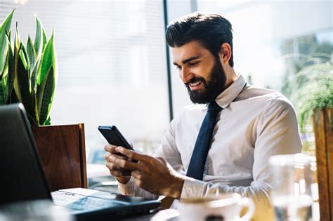 매력적인 젊은 사업가 음료 커피와 스마트 전화를 사용 하 여 개발에 대한 스톡 사진 및 기타 이미지 개발 금융 긍정적인 감정 표현 Istock