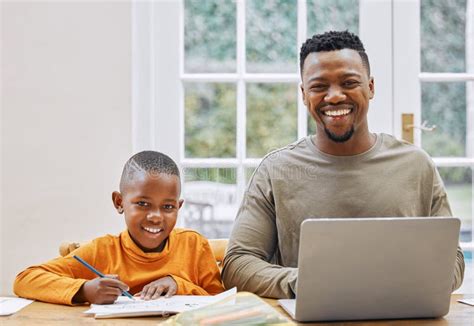 Weve Both Got Work To Do A Young Father Using A Laptop While His Son Does Homework At Home