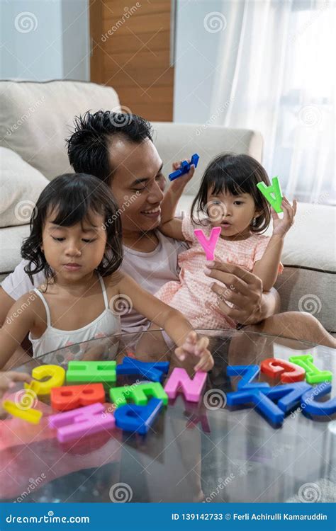 Portrait Of Togetherness Father And His Two Daughters Playing Colorful Alphabet Text Stock Image