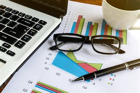 Laptop On Desk Office And Graph Analysis Spreadsheet Stock Image