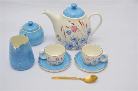 우아하고 전통적인 도자기 파란색과 흰색의 우아한 꽃 도자기 중국 세라믹 차 커피 컵과 찻주전자 및 접시 세트의 모형 디자인 세트와 흰색 배경에 격리된 금숟가락 음료 용기 0