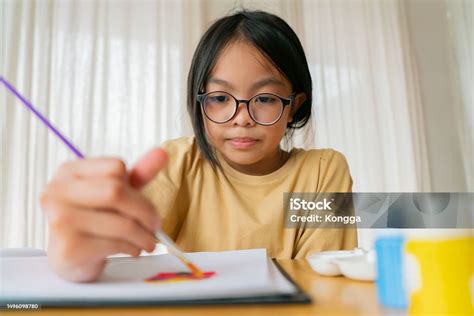 어린 아시아 소녀는 집에서 능력을 개발하고 정신 건강을 개선하기 위해 수채화 작품을 그리고 그림을 그립니다 영감을 받아 그림을