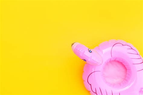 여름 해변 구성입니다 노란색 배경에 고립 된 분홍색 팽창식 플라밍고와 단순히 최소한의 디자인 수영장 플로트 파티 트렌디 한 유명