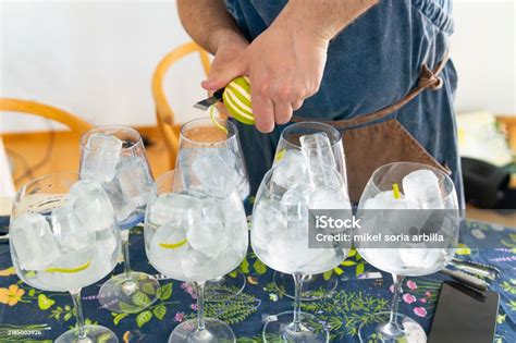 웨이터는 얼음 조각과 함께 타원형 유리잔에 자유롭게 흐르는 큐브를 준비하고 바텐더 도구로 레몬 조각을 자릅니다 과일에 대한 스톡 사진 및 기타 이미지 Istock