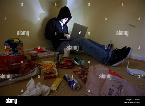 Computer User Hacker Sits Conspiratorially In An Empty Apartment