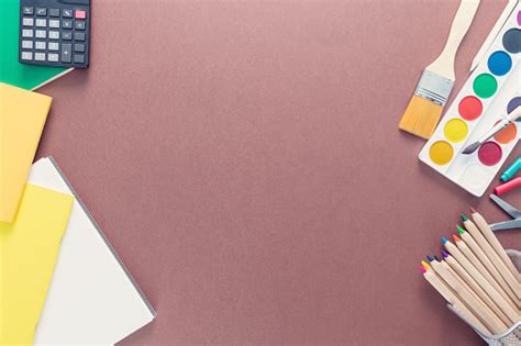 학교와 갈색 배경 위에 평면도에 제공합니다 노트북 페인트 브러쉬 색깔된 연필 왼쪽 및 오른쪽에서 계산기 텍스트에 대 한 공간을 복사 합니다 학교와 교육 개념 돌아가기 가위에