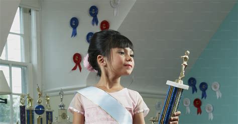 트로피를 들고 있는 분홍색 드레스를 입은 어린 소녀 사진 Unsplash의 어워드 이미지