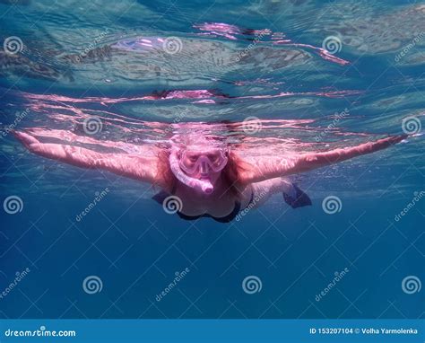 Woman In Bikini Swims Underwater With Snorkel Her Arms Spread To The