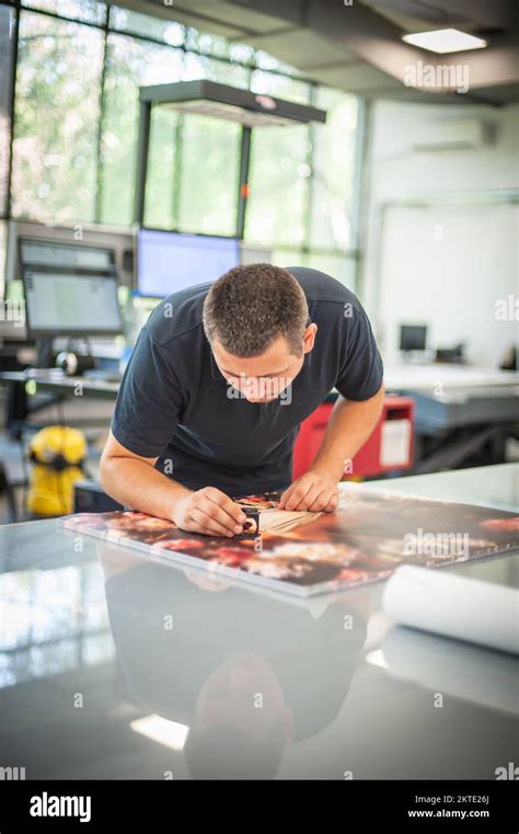 Young Man In The Process Of Printing Used Color Scales And Loupe And