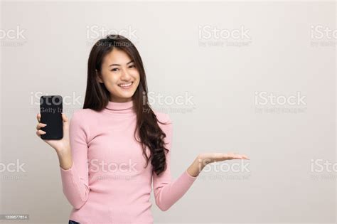 스마트 폰의 화면을 보여주는 예쁜 젊은 아시아 여성과 고립 된 흰색 배경에 서 뭔가를 들고 손을 손바닥 그녀는 매우 행복합니다 18 19세에 대한 스톡 사진 및 기타 이미지