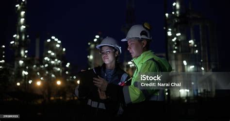 야간 근무 산업 엔지니어링 팀은 안전 장비 슈트를 착용한 채 정유 공장에서 근무를 시작하기 전에 디지털 태블릿을 사용하여 계획을 논의합니다 2명에 대한 스톡 사진 및 기타