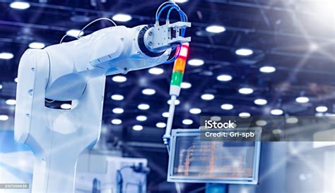 산업용 암 매니퓰레이터 생산을 위한 최신 로봇 데이터가 있는 모니터 근처의 손 조작기 제조를 위한 프로그래밍 가능한 로봇 공장의