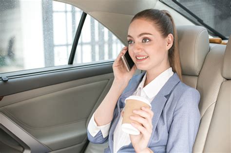 매력적인 여성이 자동차에 앉아있는 동안 스마트폰 사용 하 여 작동 개념 시간 외에 작동 하는 여자 개념에 대한 스톡 사진 및 기타 이미지 Istock