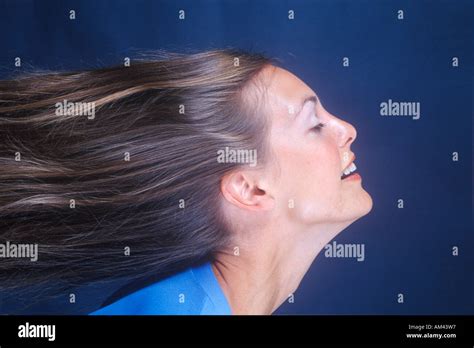 A Woman With Her Head Leaning Back And Long Brown Hair Flowing Down