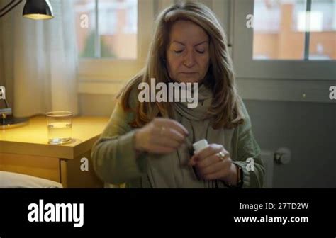 Woman Opening A Bottle Of Pills And Taking One For The Symptoms Of Flu