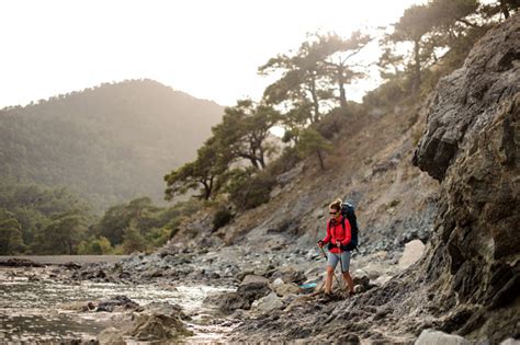 Gadis Langsing Berjalan Di Bebatuan Di Garis Pantai Di Laut Dengan Ransel Hiking Foto Stok