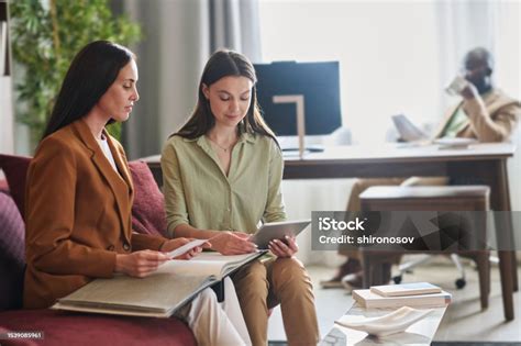 태블릿과 카탈로그를 들고 있는 두 명의 젊은 크리에이티브 디자이너의 측면 모습 20 24세에 대한 스톡 사진 및 기타 이미지 20 24세 25 29세 30 34세