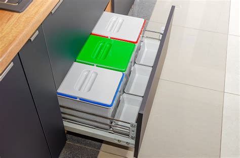 부엌 캐비닛 클로즈업에서 쓰레기를 분류하기위한 세 가지 쓰레기 용기 현대 아름 다운 부엌 생태 및 폐기물 처리의 개념 쓰레기통에