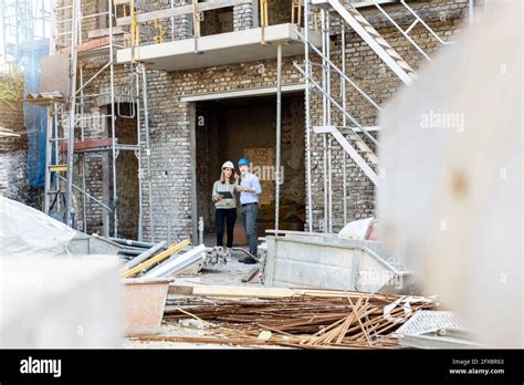 Female Client Discussing With Male Architect While Standing At Construction Site Stock Photo Alamy