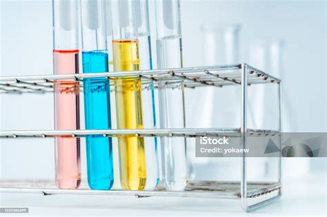실험실 테스트 튜브의 클로즈업튜브 랙에 빨간색 파란색 노란색 및 맑은 액체 배경 화학 또는 교육 개념의 흐린 실험실 비커로 가득 Stem 주제에 대한 스톡 사진 및 기타