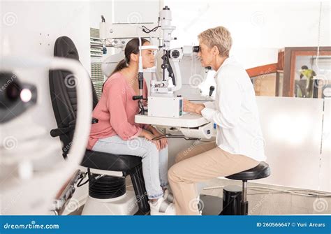 Woman Optometrist Testing Eyesight On A Machine With Patient Consult In