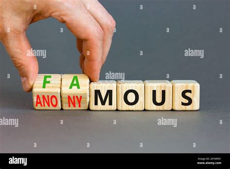 Famous Or Anonymous Symbol Concept Word Famous And Anonymous On Wooden Cubes Businessman Hand
