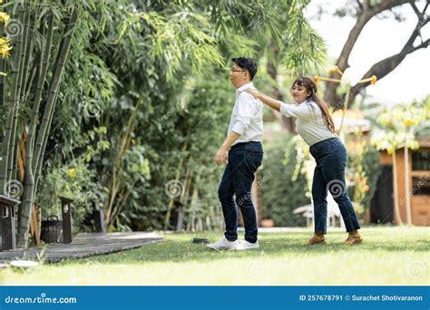Asian Woman Grabbing And Catching Man Shoulder And Bracing The Man To